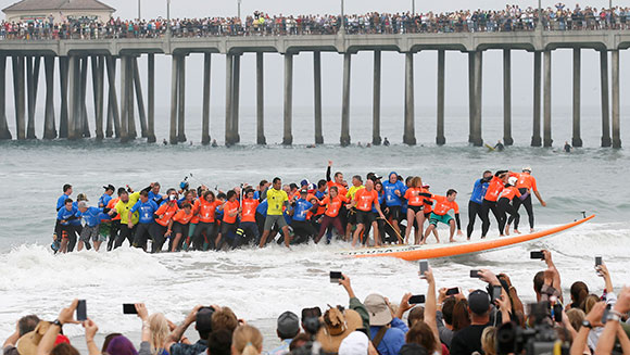 World's largest surfboard: 66 catch a wave and ride their way to a ...