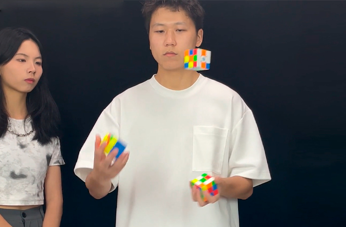 Three puzzle cubes juggled and solved simultaneously to break record ...