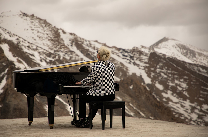 Musician braves freezing conditions to stage piano performance high in ...