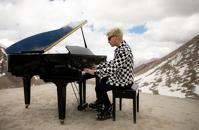 Musician braves freezing conditions to stage piano performance high in ...